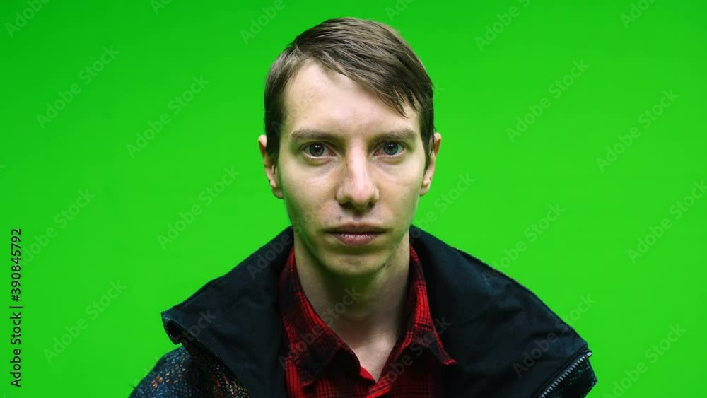 Young upset sad man looking at camera on green screen background ...