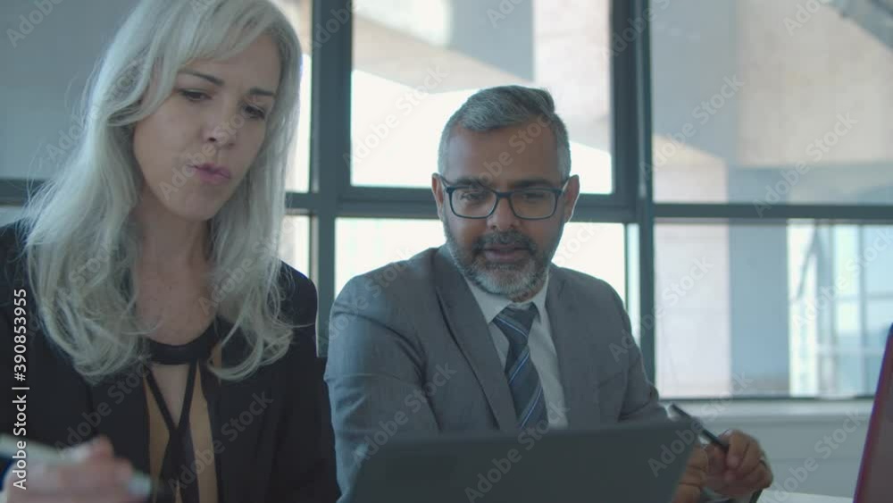 Positive business colleagues watching and discussing presentation on ...