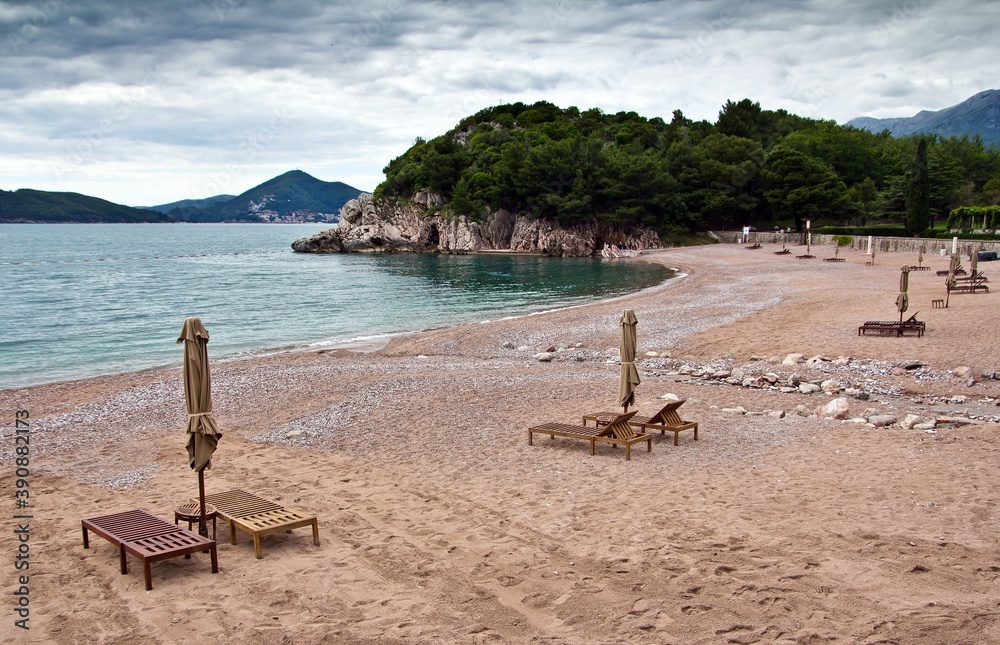 Sandy Queen's and King's beach with sunbeds and closed umbrellas of ...
