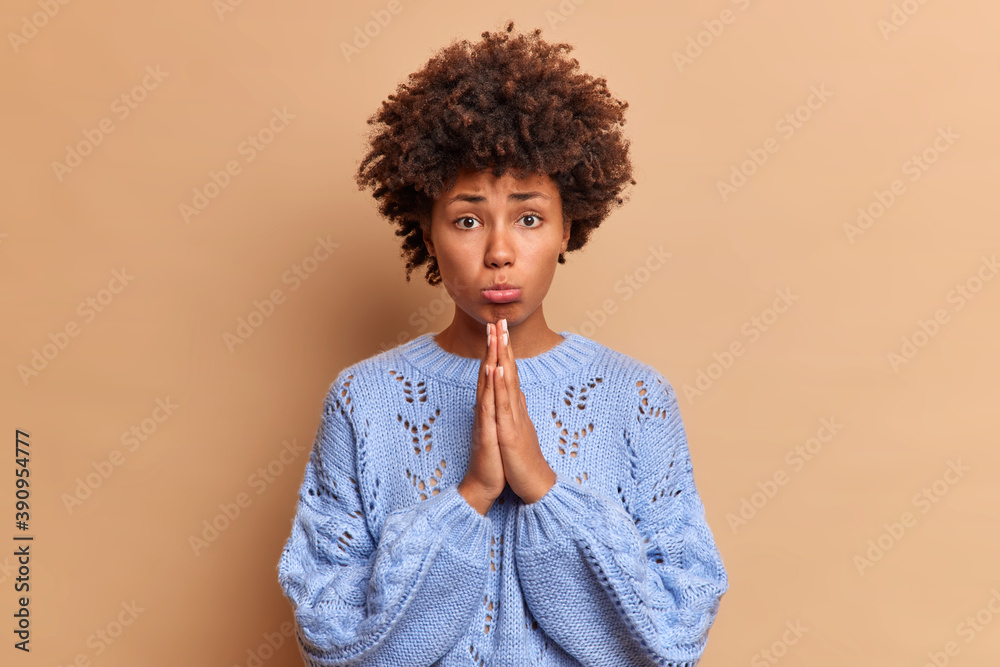 Sad dark skinned young woman asks for forgiveness keeps palms pressed ...