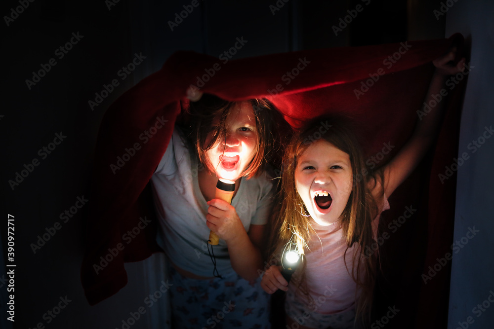 Crazy kids under a blanket with flashlights, scary stories and horror ...