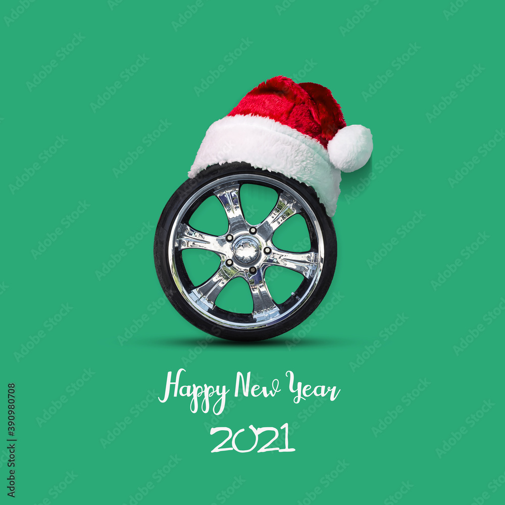 Car wheel in the hat of Santa Claus, on a green background ...