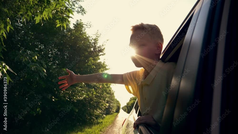 Happy child stretched out his hand from the car window. Happy family ...