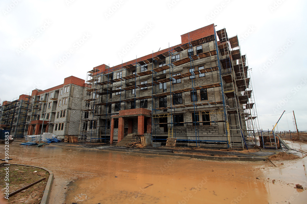 Tall building under construction with scaffolds. Construction site ...