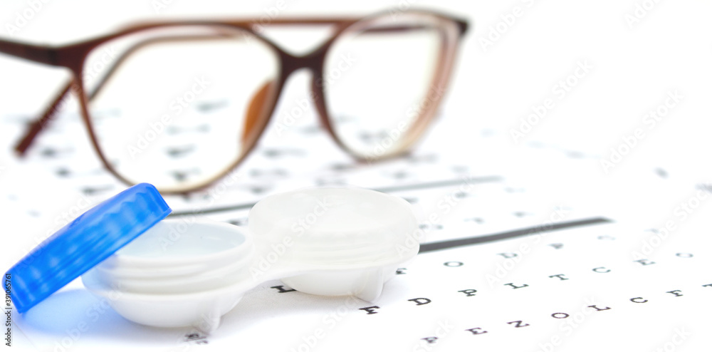 Contact lenses case and eye glasses on and eye test chart. Vision ...