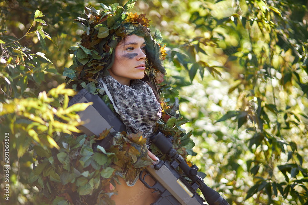 young caucasian clever woman deer hunter in green uniform with disguise ...