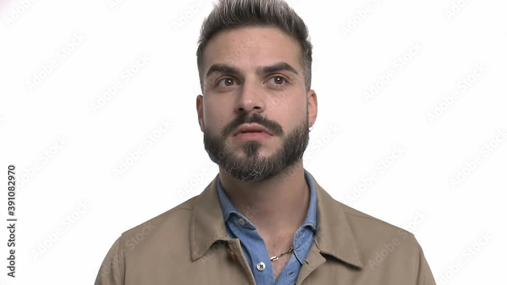 clueless guy wearing denim shirt, looking around, curiously holding ...