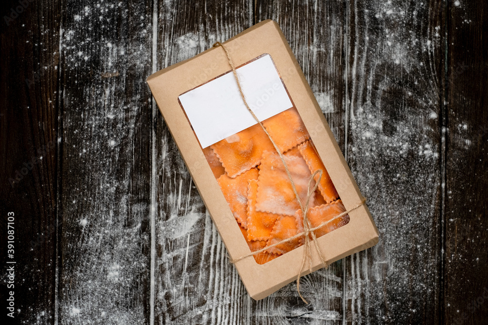 Colored fresh pumpkin ravioli in a package with an empty space for the ...