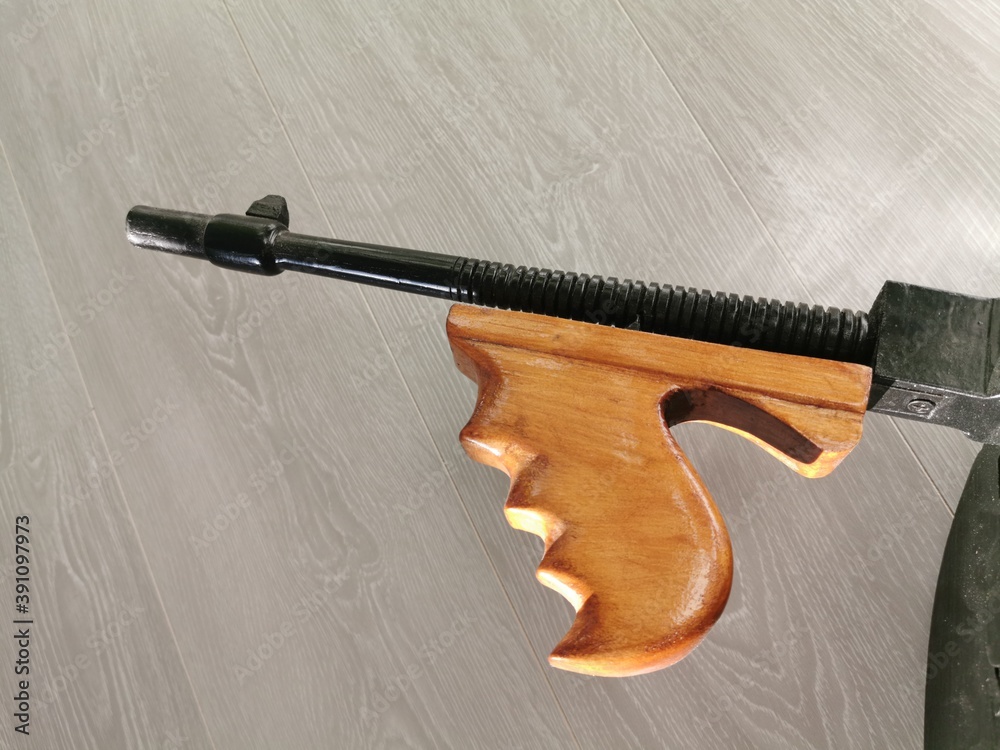 Hanged wooden thompson machine gun and automatic rifle toys at counter ...
