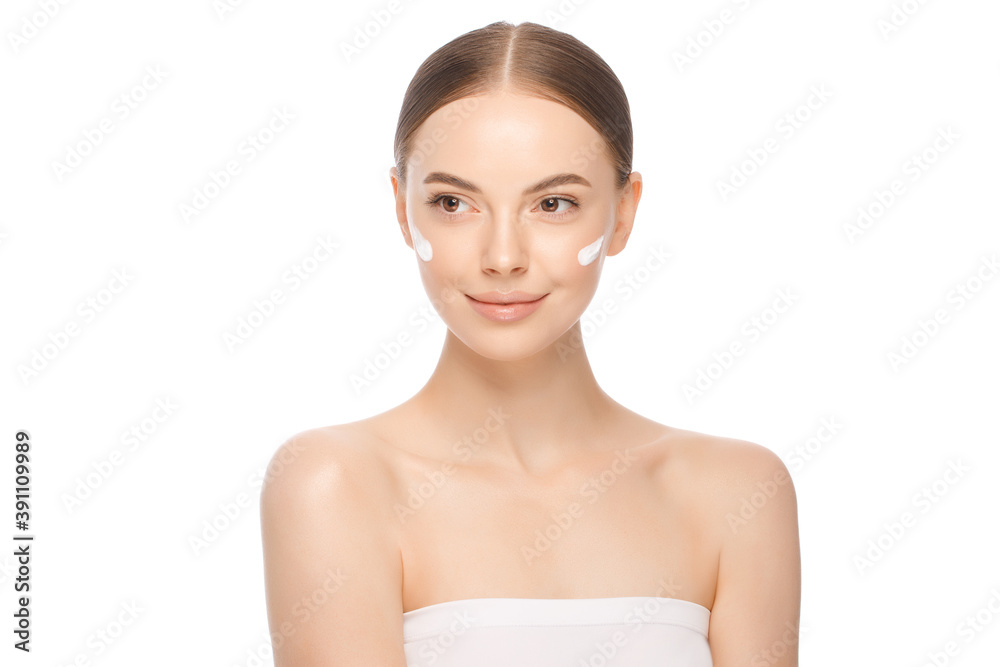 Beautiful woman looking away after applying face cream to cheeks as ...