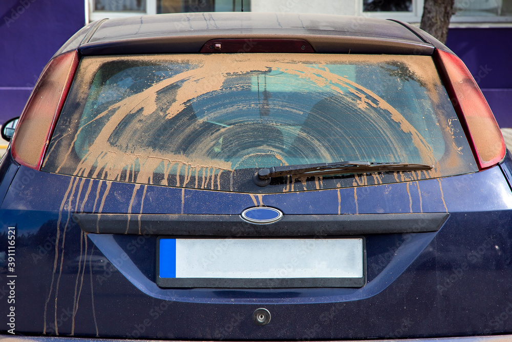 dirty car crossover covered with a dry layer of dust from clay smeared ...