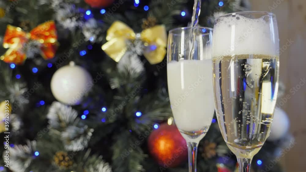 Champagne is pouring into wine glasses. Christmas and holiday season ...