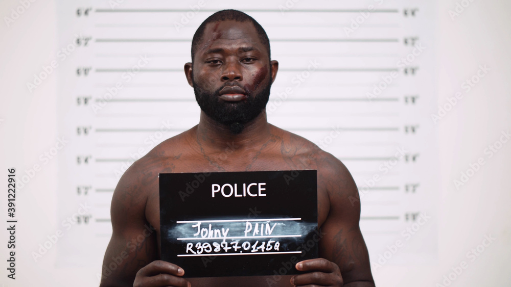 Foto de In a police station african arrested beaten man poses for front ...