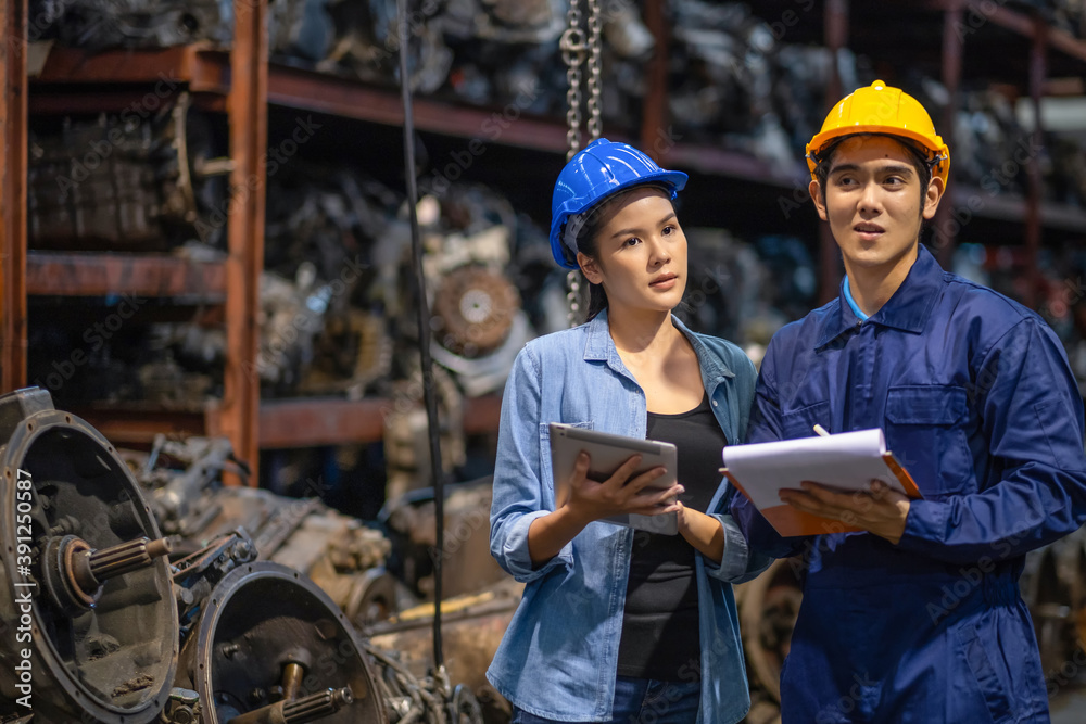 Confident Asia engineer woman worker wears a safety helmet holding ...