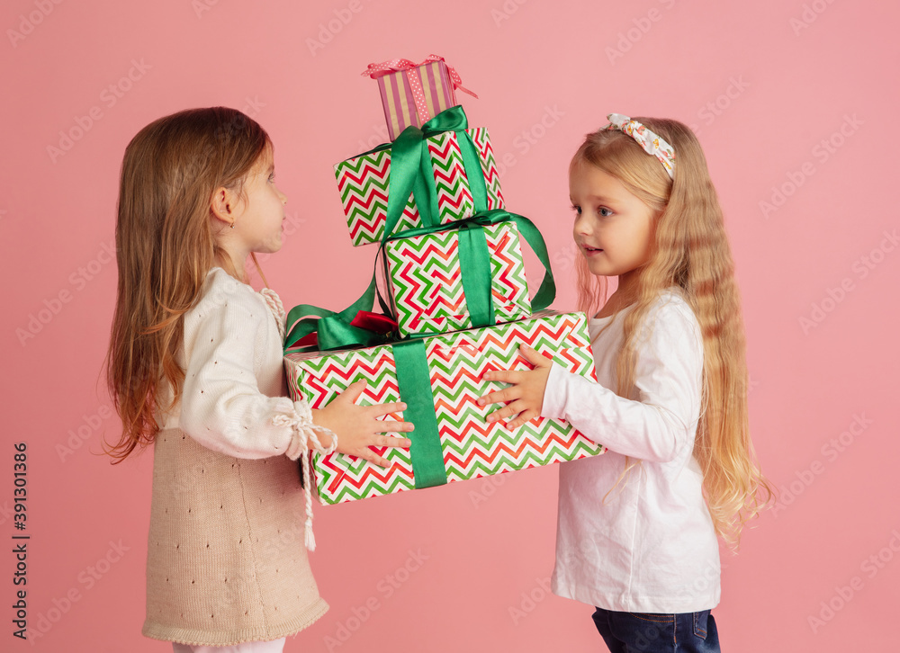 Giving and getting presents on Christmas holidays. Two little smiling ...