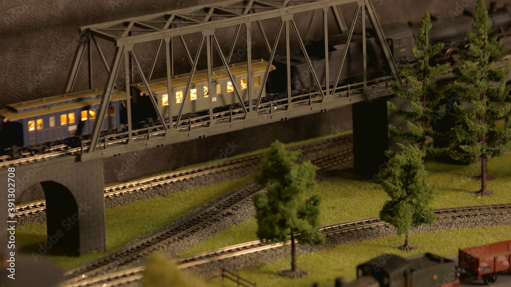 Model of retro train with passangers. Miniature railway with bridge and ...