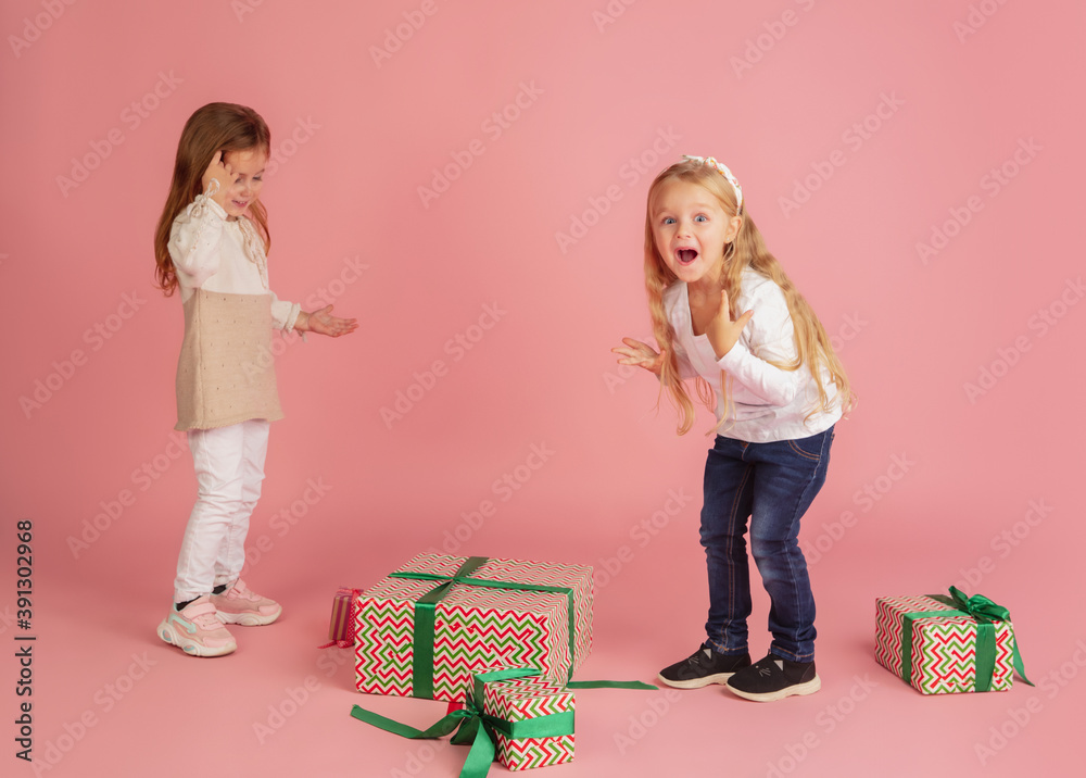 Giving and getting presents on Christmas holidays. Two little smiling ...