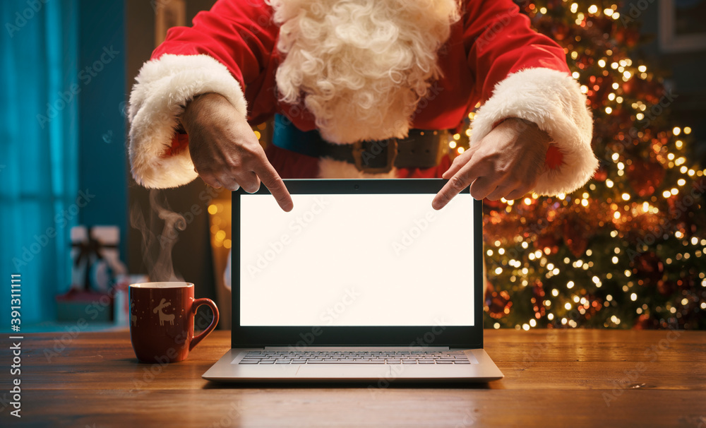Santa Claus pointing at the laptop screen Stock Photo | Adobe Stock