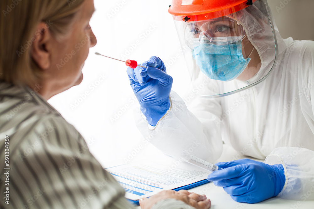 Physician wearing personal protective equipment performing a ...