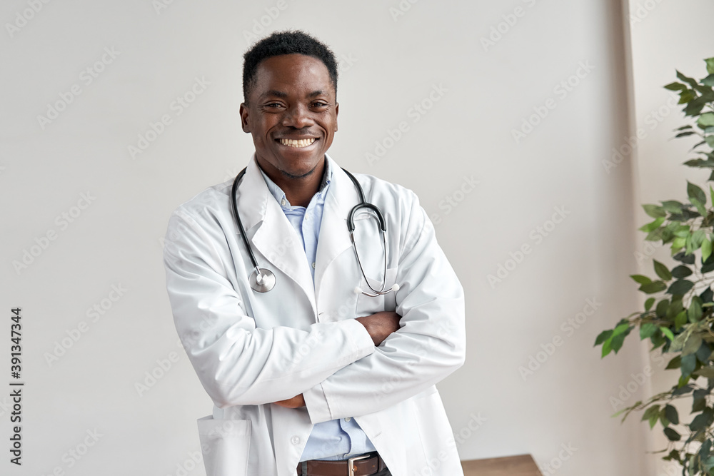 Happy african male doctor wearing white coat, stethoscope looking at ...