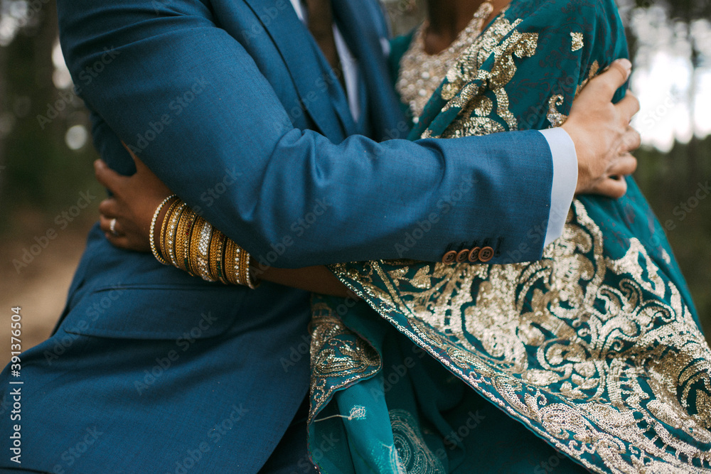 Indian bride and groom with blue costume holding and cuddling each ...