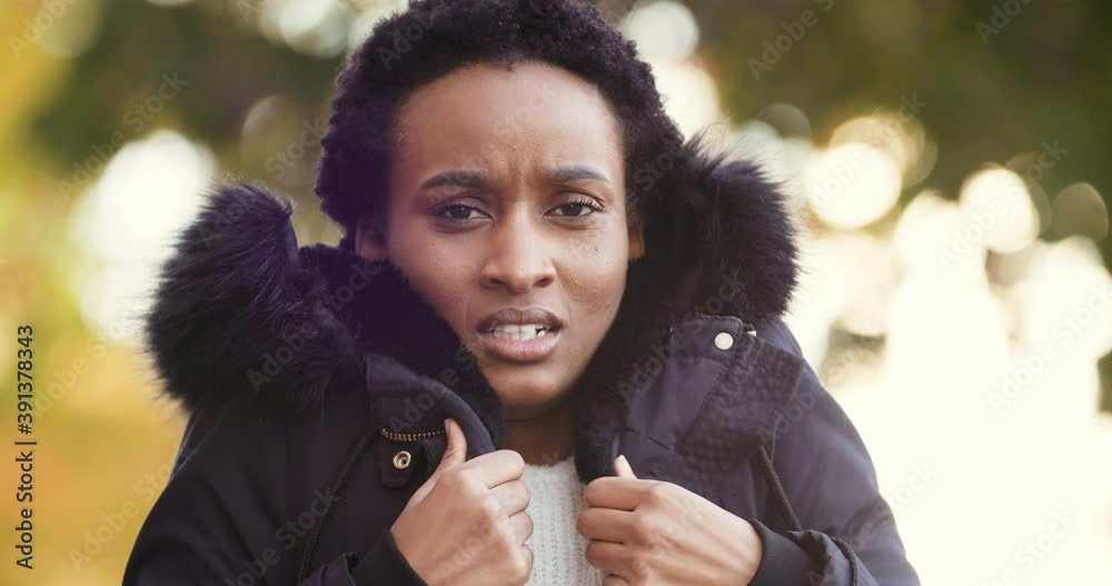 Portrait of frozen african american young woman wears warm jacket ...