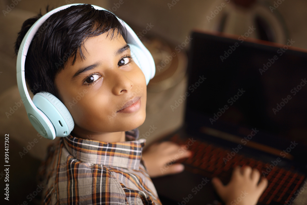 Portrait of Indian little boy using laptop while attending the online ...