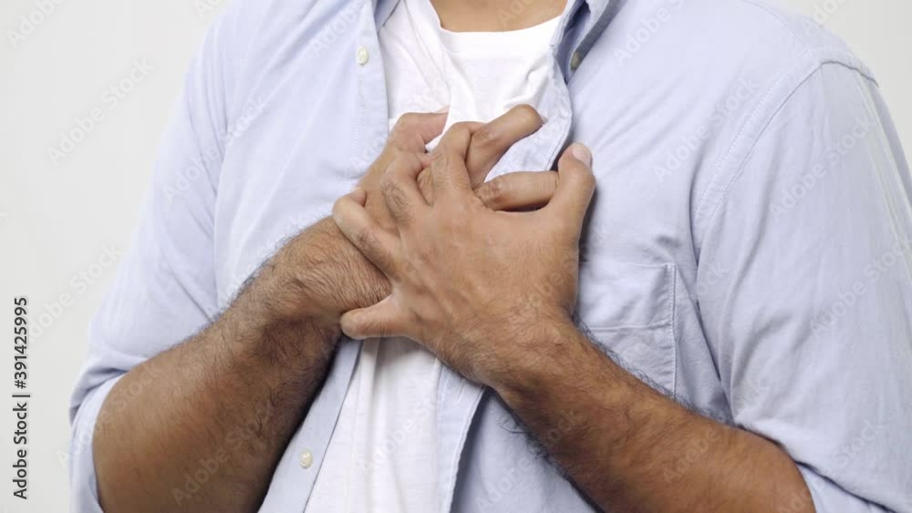 Close up. Man holding his chest with both hands, having heart attack or ...