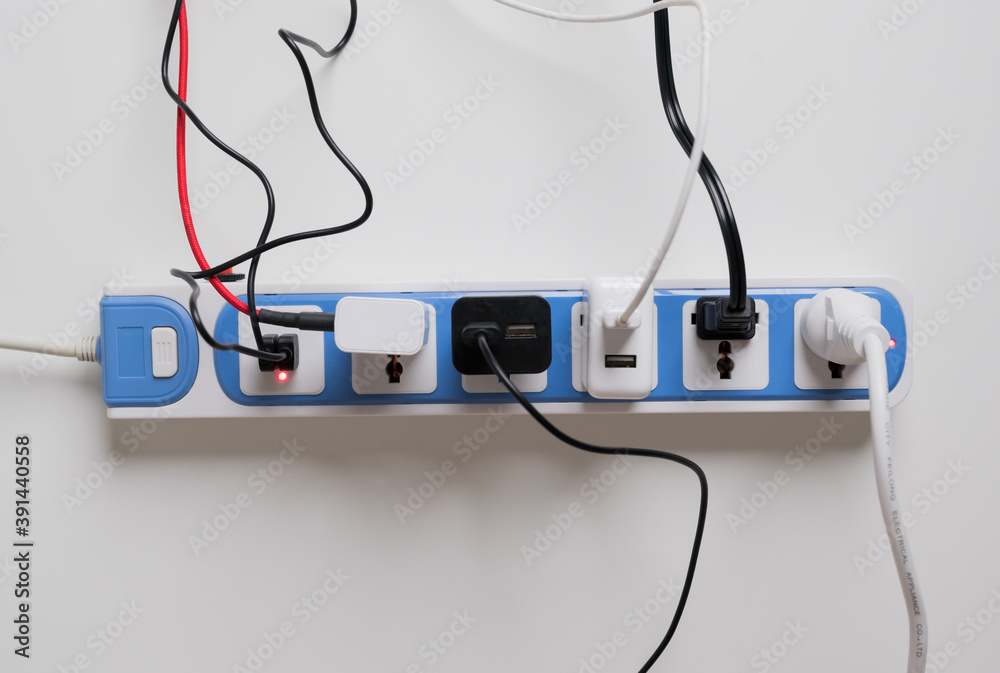 A lot of electric cable plugged in socket. Risk of electric shock ...