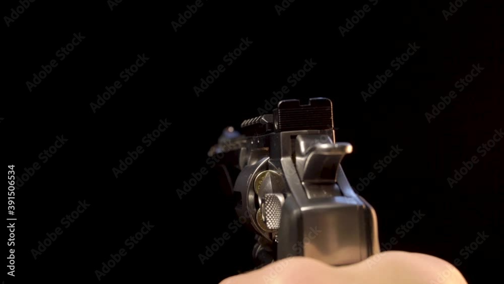 Aiming and firing a revolver pistol on a black background is isolated ...