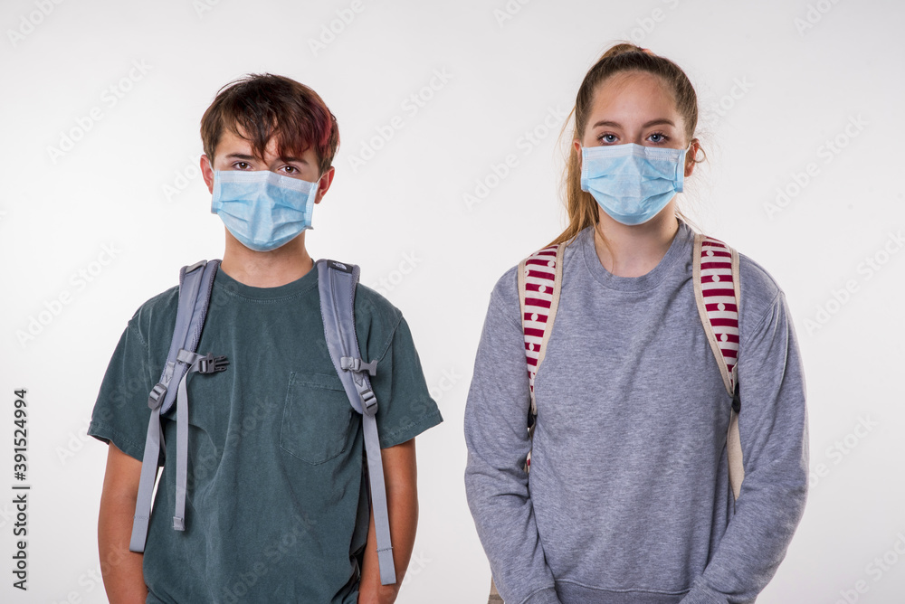 Girl and boy high school students standing side by side wearing virus ...
