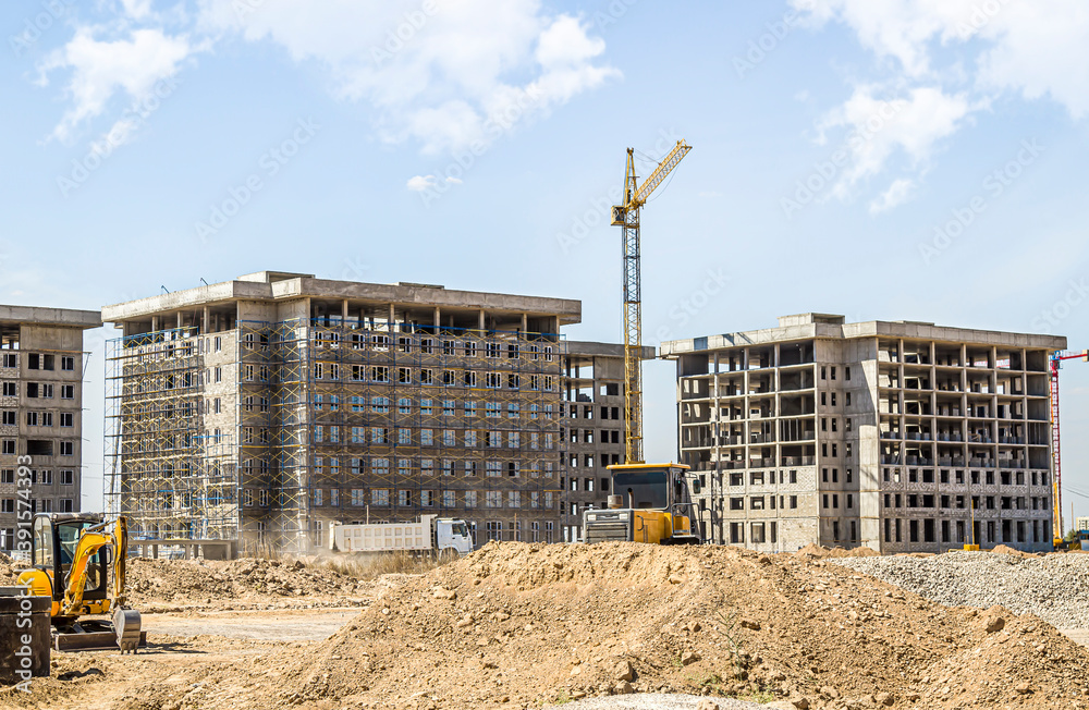 High-rise buildings under construction in scaffolding against the ...