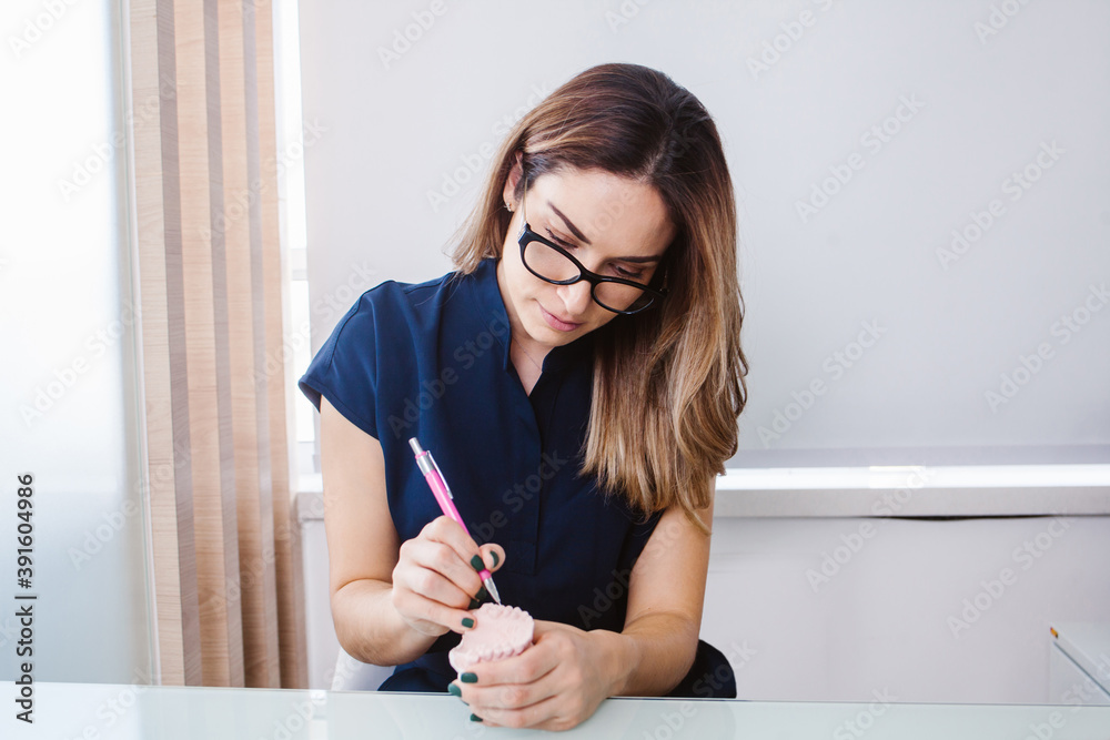 Woman dentist counting teeth on cast of teeth from plast Stock Photo ...