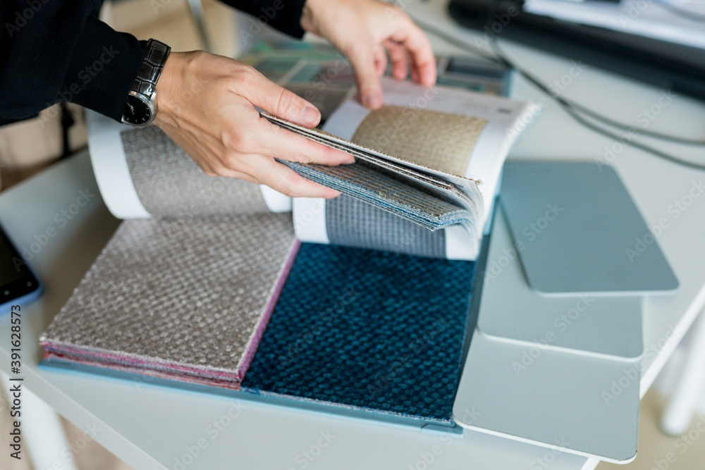 Close-up woman choosing fabrics swatches for sofa in store. Interior ...
