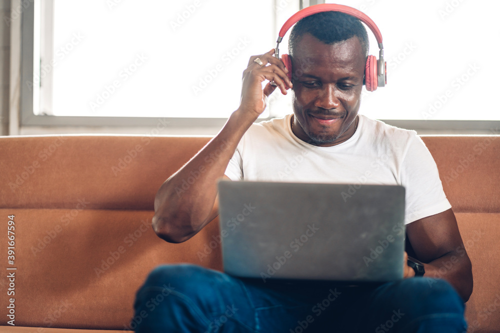 Young black african man relaxing using laptop computer working and ...