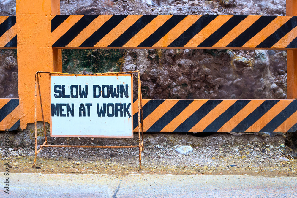 Danger sign on orange black slope protection with mountain rocks ...