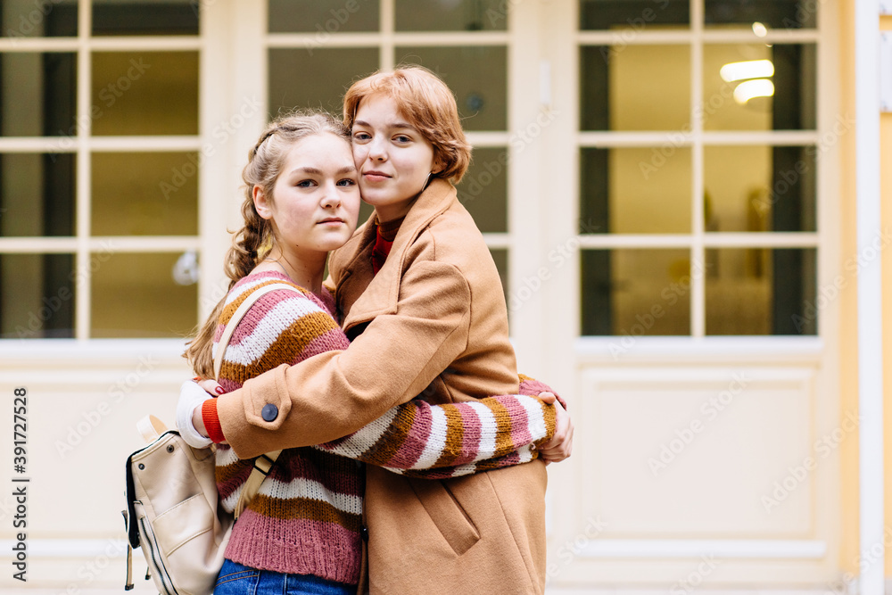 Happy best friends embracing. Sad girl crying and her sisiter ...