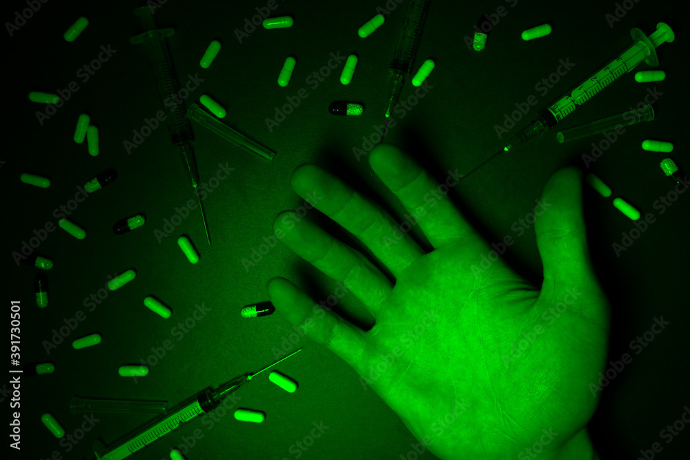 Drugs addiction concept. Drugs injection. Hand surrounded by used ...