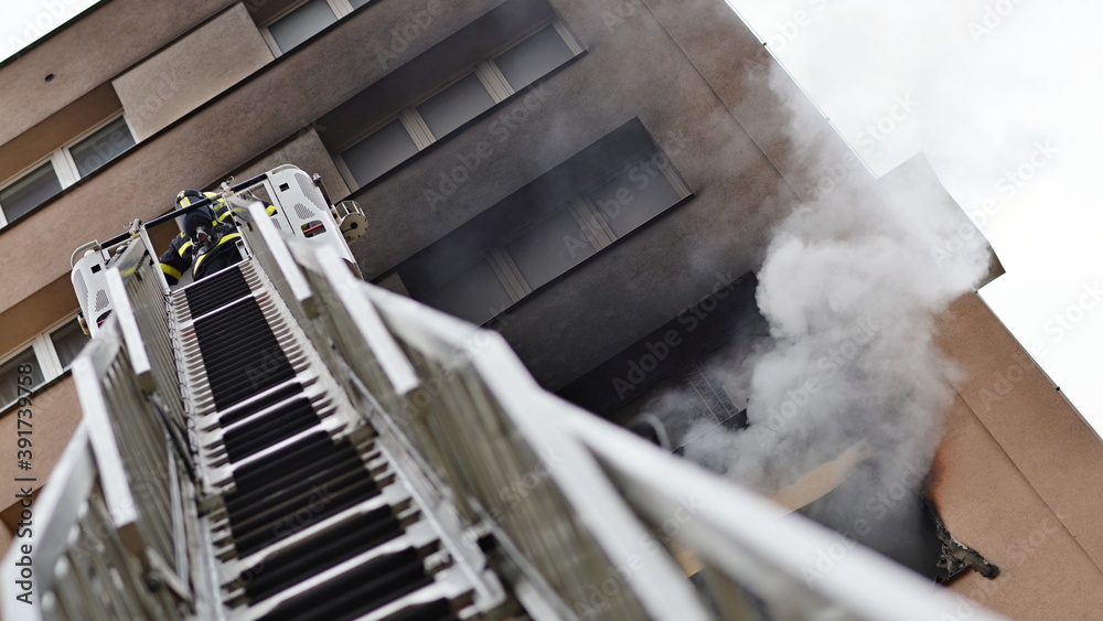 Fire truck ladder at a fire in a high-rise apartment building with ...