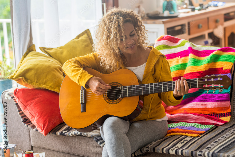 Beautiful middle age woman play guitar at home - music lesson and ...