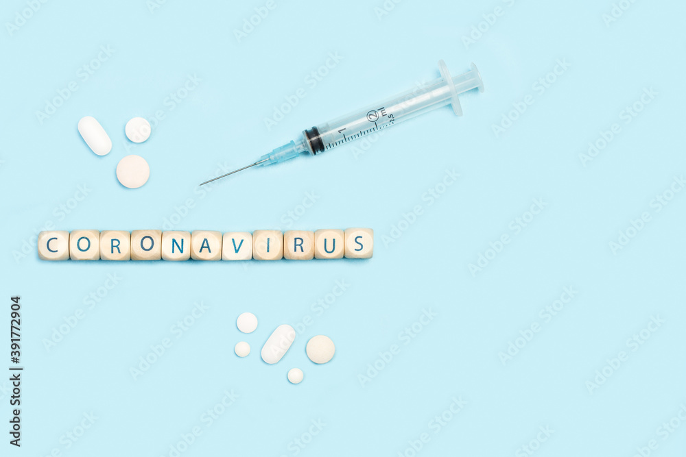 Coronavirus palabra escrita con cubos de madera junto a una jeringa y ...