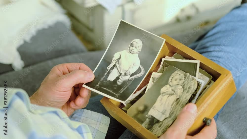 an elderly man looks through his old photographs of 1960-1965, the ...