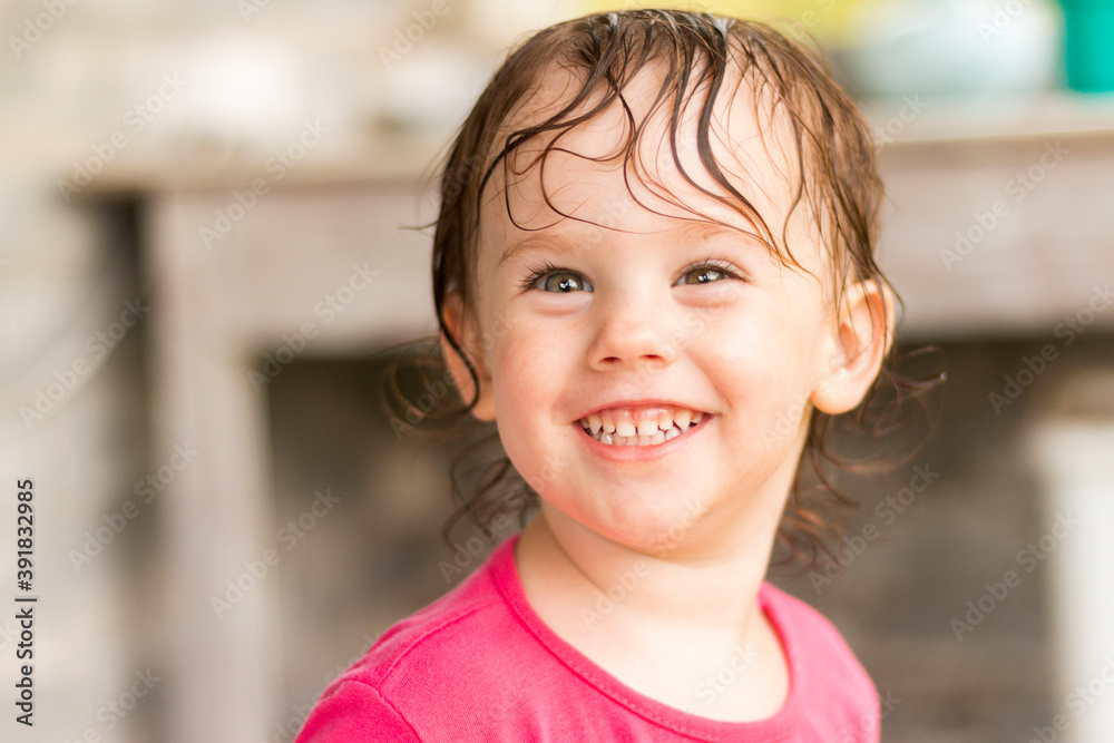 Shining smiling child with wet hair on blurred summer background ...