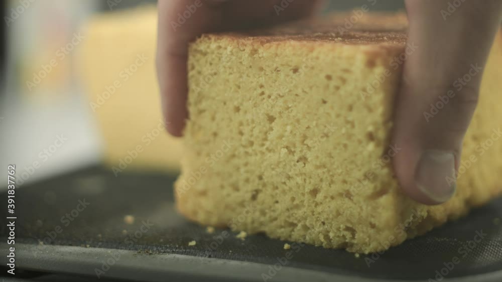 A chef testing the consistency of a freshly baked vegan sponge cake ...
