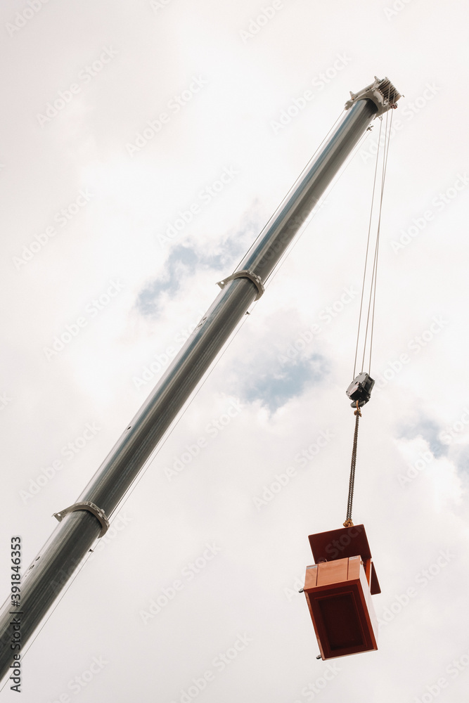 Raised high in the sky cradle of a car crane. The tallest truck crane ...