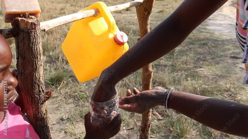Young girl washing hands on gallon of water recycled and adapted on ...