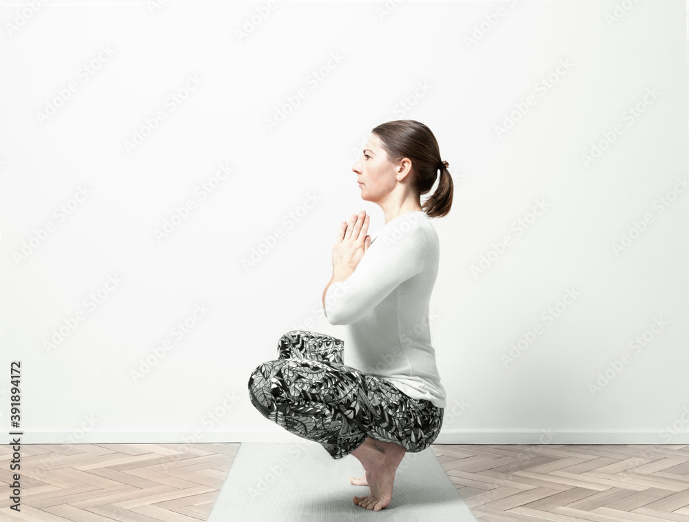 Adult Caucasian woman doing yoga sitting posture viewed in profile with ...