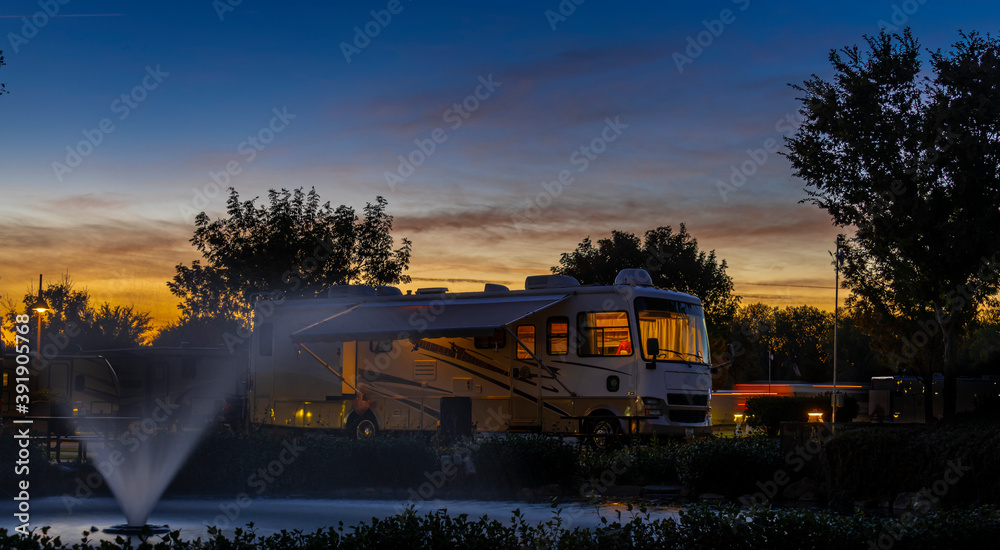 Camping at a Rv park with a water fountain with lights under a colorful ...