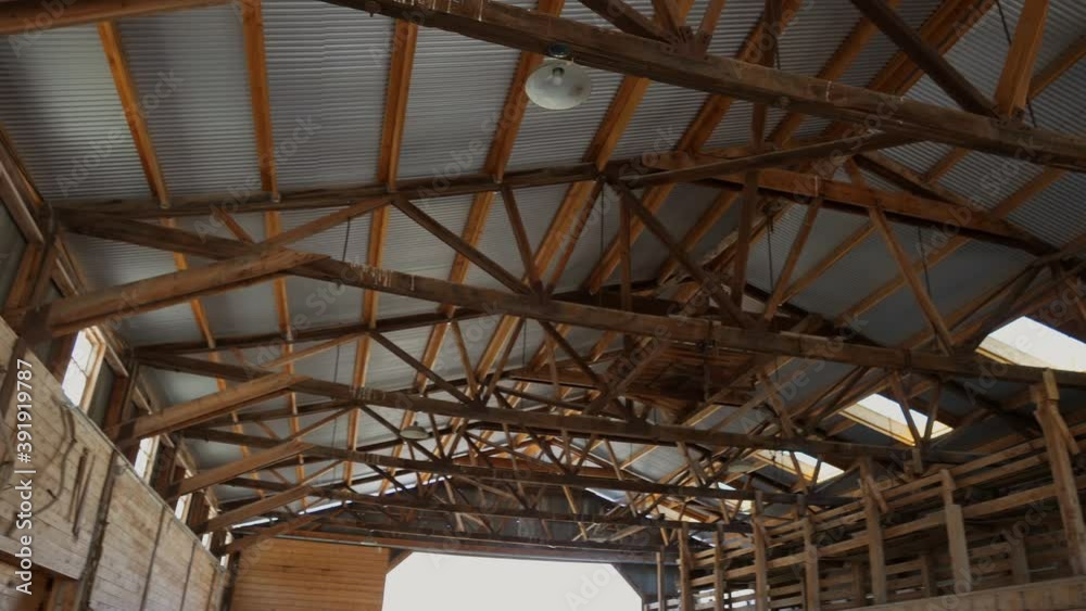 This panning video shows open frame exposed wooden architectural beams ...