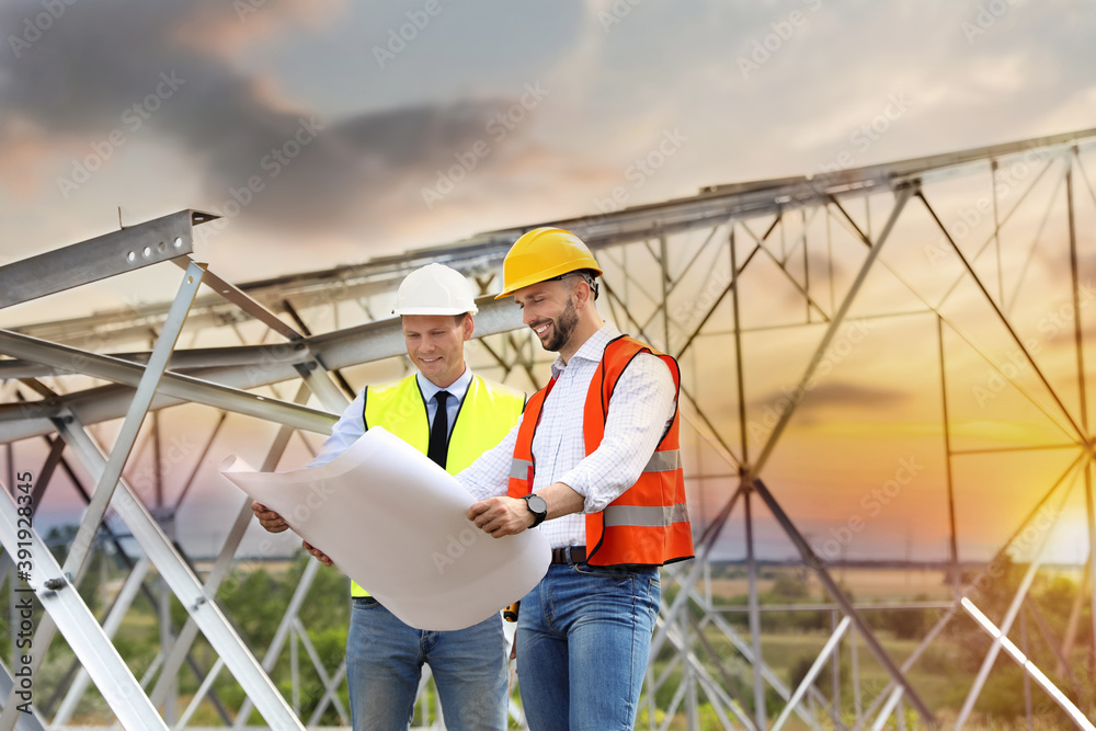 Professional engineers working on installation of electrical substation ...